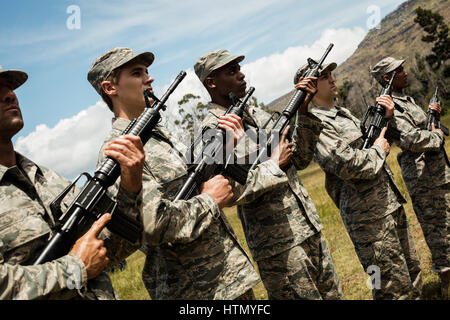 Group of military soldiers standing with rifles at boot camp Stock ...