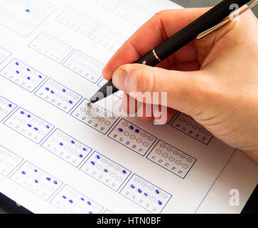 Marking the answer sheet with a pencil while taking a exam at school ...