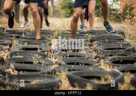 People receiving tire obstacle course training in boot camp Stock Photo ...