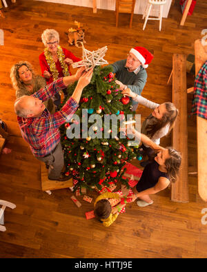 Family gathered around a Christmas tree, using a tablet Stock Photo - Alamy