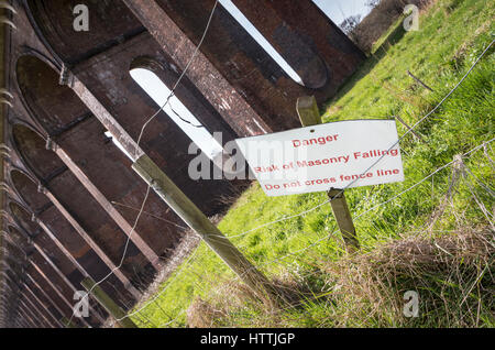 Beware falling masonry warning sign in a churchyard at Brancaster ...