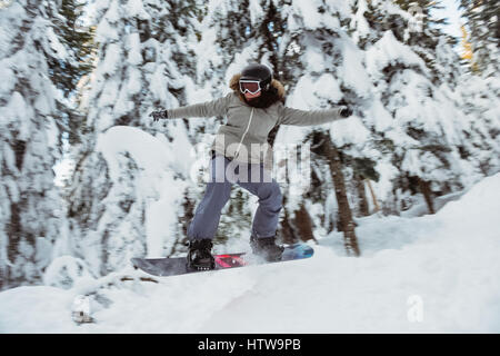 young snowboarder woman jumping over the slope in winter Stock Photo ...