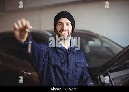 smiling mechanic holding car key in auto repair shop Stock Photo - Alamy