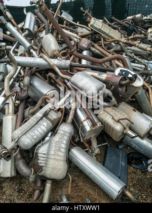 Car exhaust pipe silencers and brake disk in scrap heap for disposal at ...