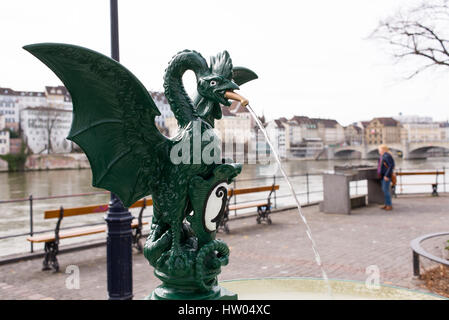 Dragon water fountain on Basel river front with people, river Rhine and ...