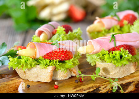 Dainty morsels with ham rolls and white asparagus with fresh ...