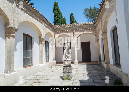 Cartuja monastery courtyard with sculpture of a saint in the center ...