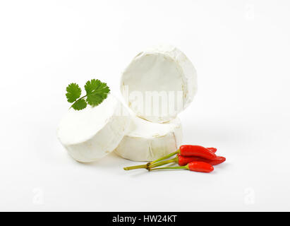 Wheels of soft white cheese and red chili peppers Stock Photo - Alamy