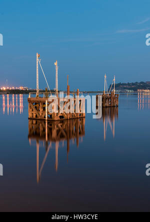 Old wooden jetty reflected in waters of the Ultima Esperanze Sound ...