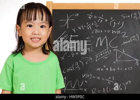 Asian Chinese children againts blackboard or chalkboard with formulas ...