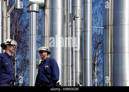 MODEL RELEASED. Oil refinery workers and pipework Stock Photo - Alamy