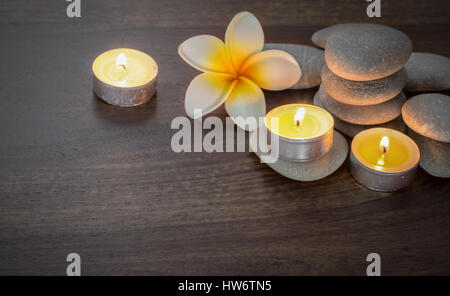 Beautiful composition with spa stones and candles on table on dark ...