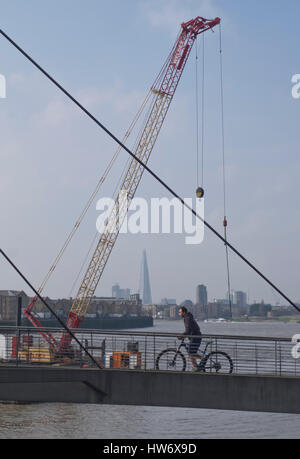 Maintenance dredging boat and cranes on river Thames by new office ...