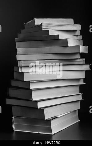 swirl of stacked books in black and white blue toned closeup Stock ...