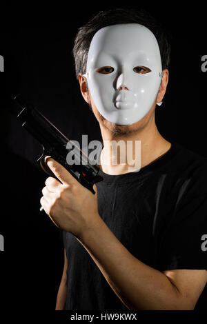 Gunman in black mask holding gun with silencer Stock Photo - Alamy