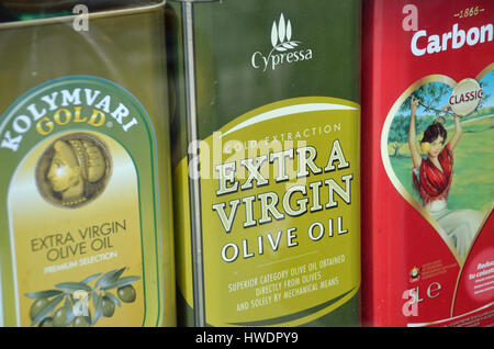 Oil cans with extra virgin olive oil on a counter with a background of ...