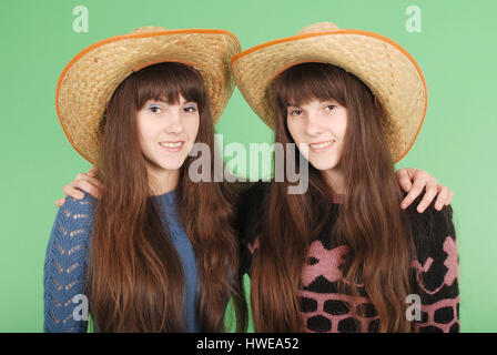 Beautiful two twins sisters on green background Stock Photo - Alamy