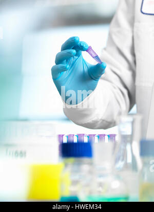 Cropped view of scientist in protective uniform holding vaccine near ...