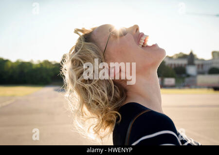 Blond woman throwing her head back Stock Photo - Alamy