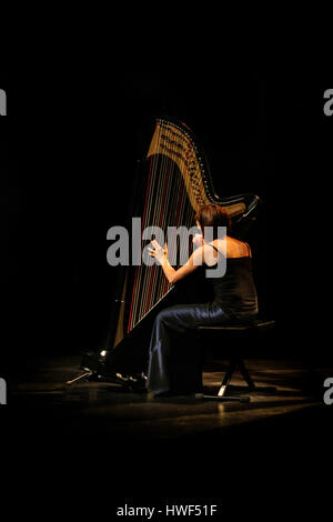 girl playing the harp on stage during a concert Stock Photo - Alamy