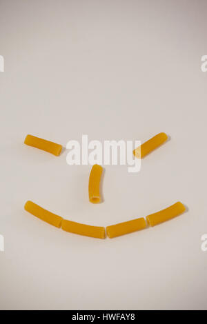 Smiley face made out of pennette pasta on white background Stock Photo ...
