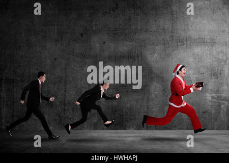 Business people chasing santa claus Stock Photo - Alamy