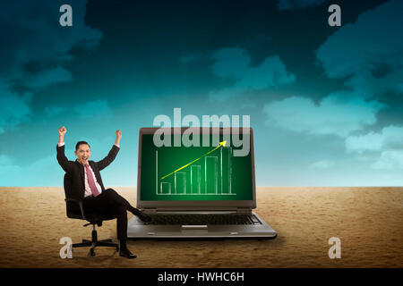 Business person looking giant laptop on the desert Stock Photo - Alamy