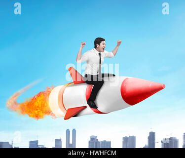 Asian business man riding rocket across the earth Stock Photo - Alamy
