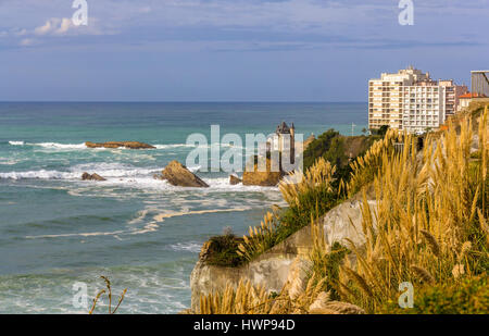 Old fashion beach stone house with bright red closed shutters alongside ...