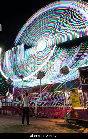 Spinning carnival ride at fair. Fast movement blurred fairground ...