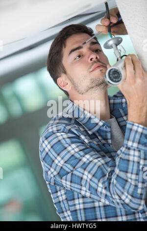 contractor fitting interior cctv camera Stock Photo - Alamy
