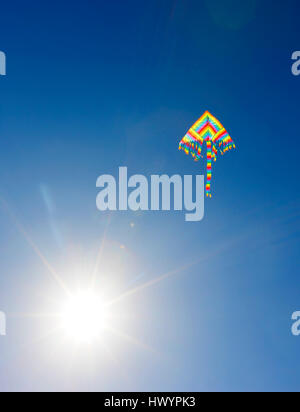 A fun and bright flying kite in the blue sky Stock Photo - Alamy