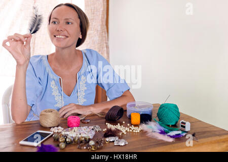 Woman is doing handicraft on wooden table Stock Photo - Alamy