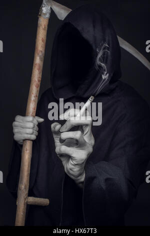 The concept: smoking kills. Grim reaper holding cigarette. Studio shot ...