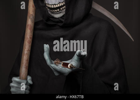 The concept: drugs kill. Grim reaper holding syringe with drugs. Studio ...