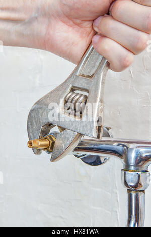 Close-up adjustable spanner plumbers screwing water faucet valve for ...