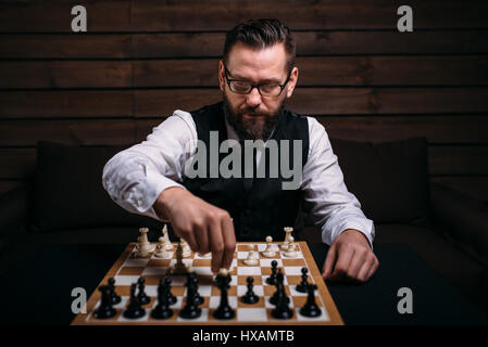 Serious male chess player in glasses makes victory move. Win strategy ...