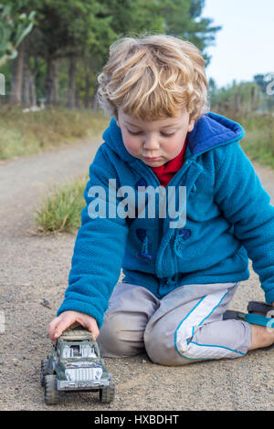a boy playing with a toy car Stock Photo - Alamy