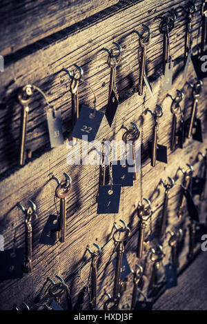 Old keys with number in hotel on wooden wall Stock Photo - Alamy