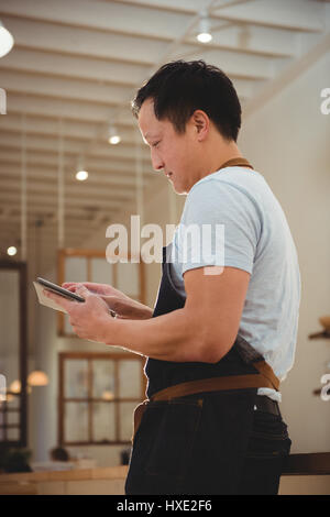 side view of barista using tablet at work in coffee shop Stock Photo ...