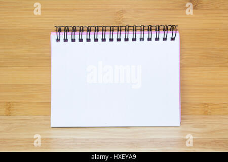 Blank paper notebook on brown wooden table background. Top view with ...