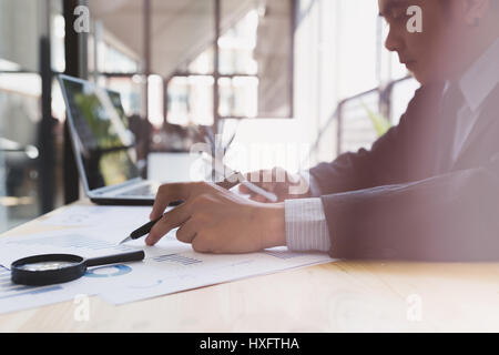 Businessman analyzing business graphs with magnifying glass. With copy ...