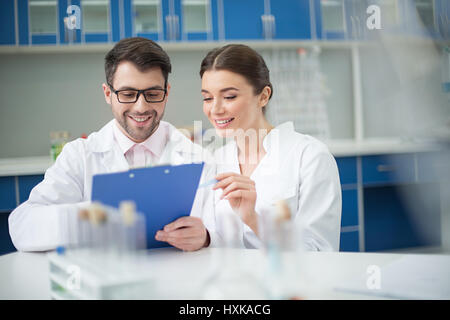 portrait of smiling scientists writing in notepad in lab Stock Photo ...