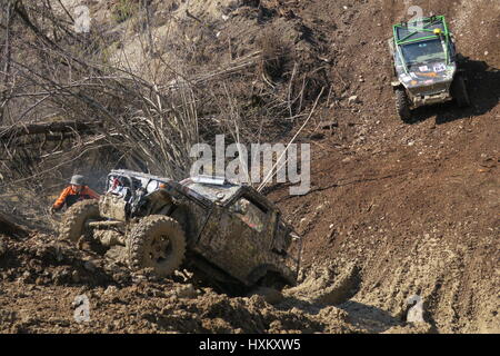 A off-road car gets stuck on a muddy hill, a four-wheel drive is pushed ...