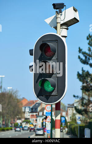 An urban city street with a green light for two traffic lights against ...