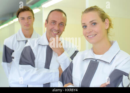 Three workers in matching overalls Stock Photo - Alamy