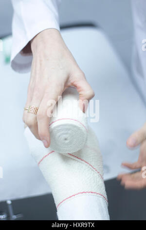 Doctor applying a plaster cast and bandages to patient forearm and ...