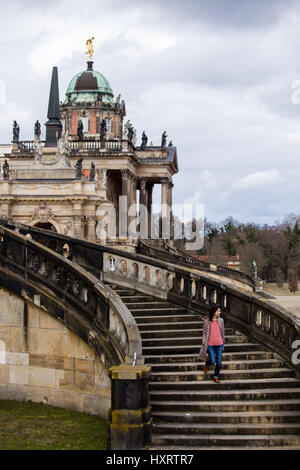 Pensive Asian female standing near wall of building with shadows on ...
