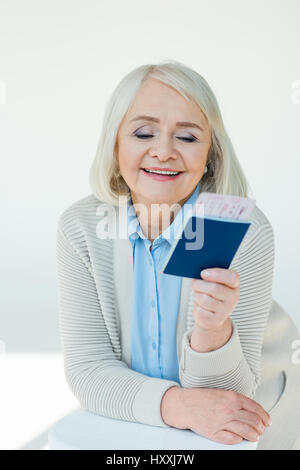 Happy senior woman with passport and travel ticket packed a red ...