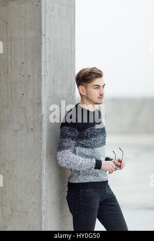 Fashionable man standing near wall with blur background Stock Photo - Alamy